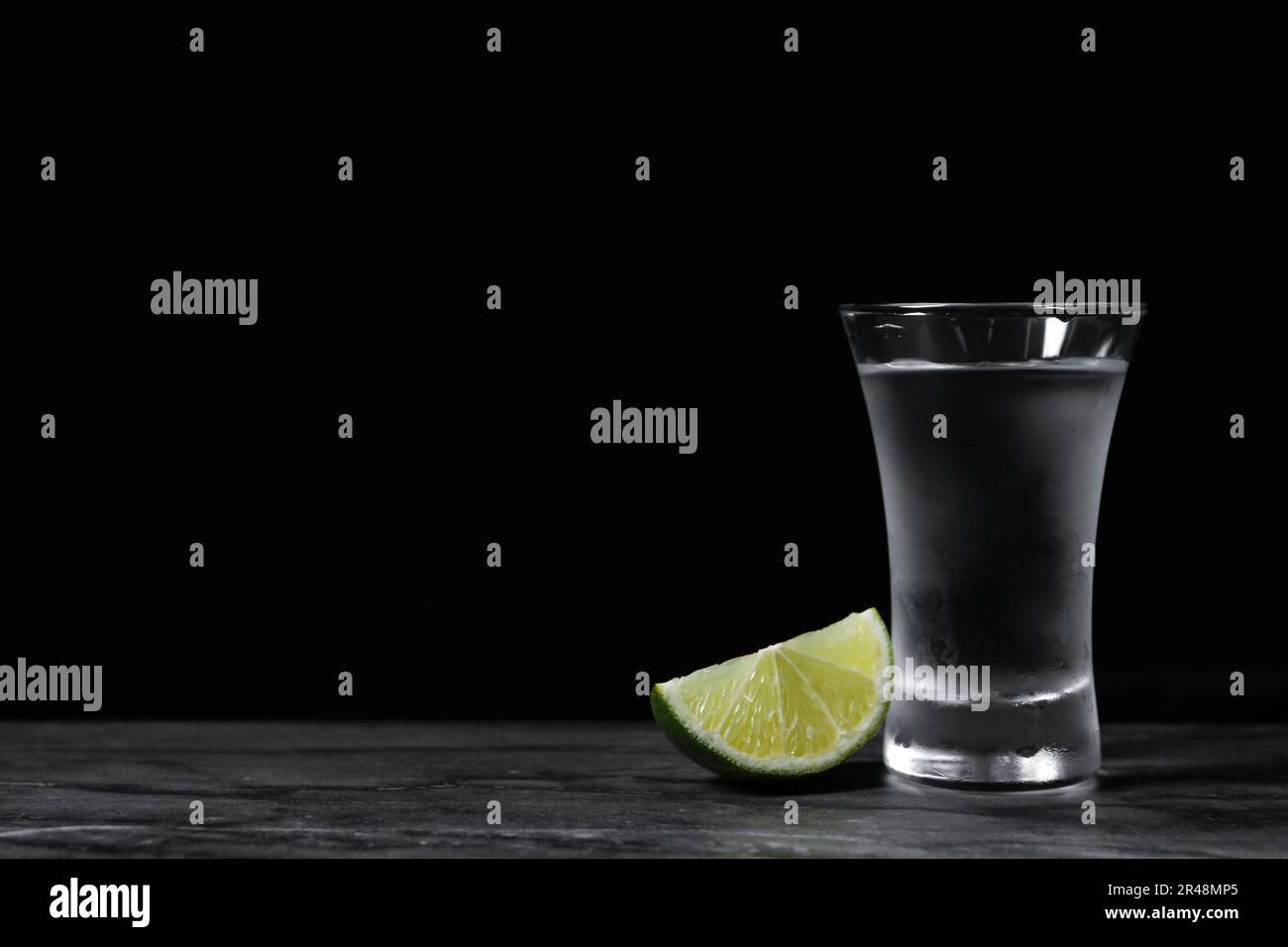 Shot of vodka with lime slice on grey table. Space for text Stock Photo ...