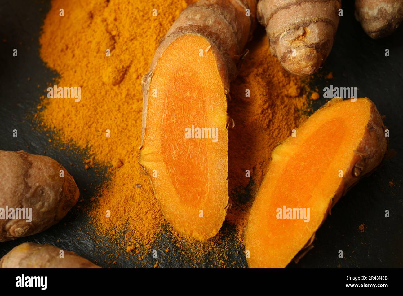 Turmeric roots and powder on black textured table, closeup Stock Photo ...