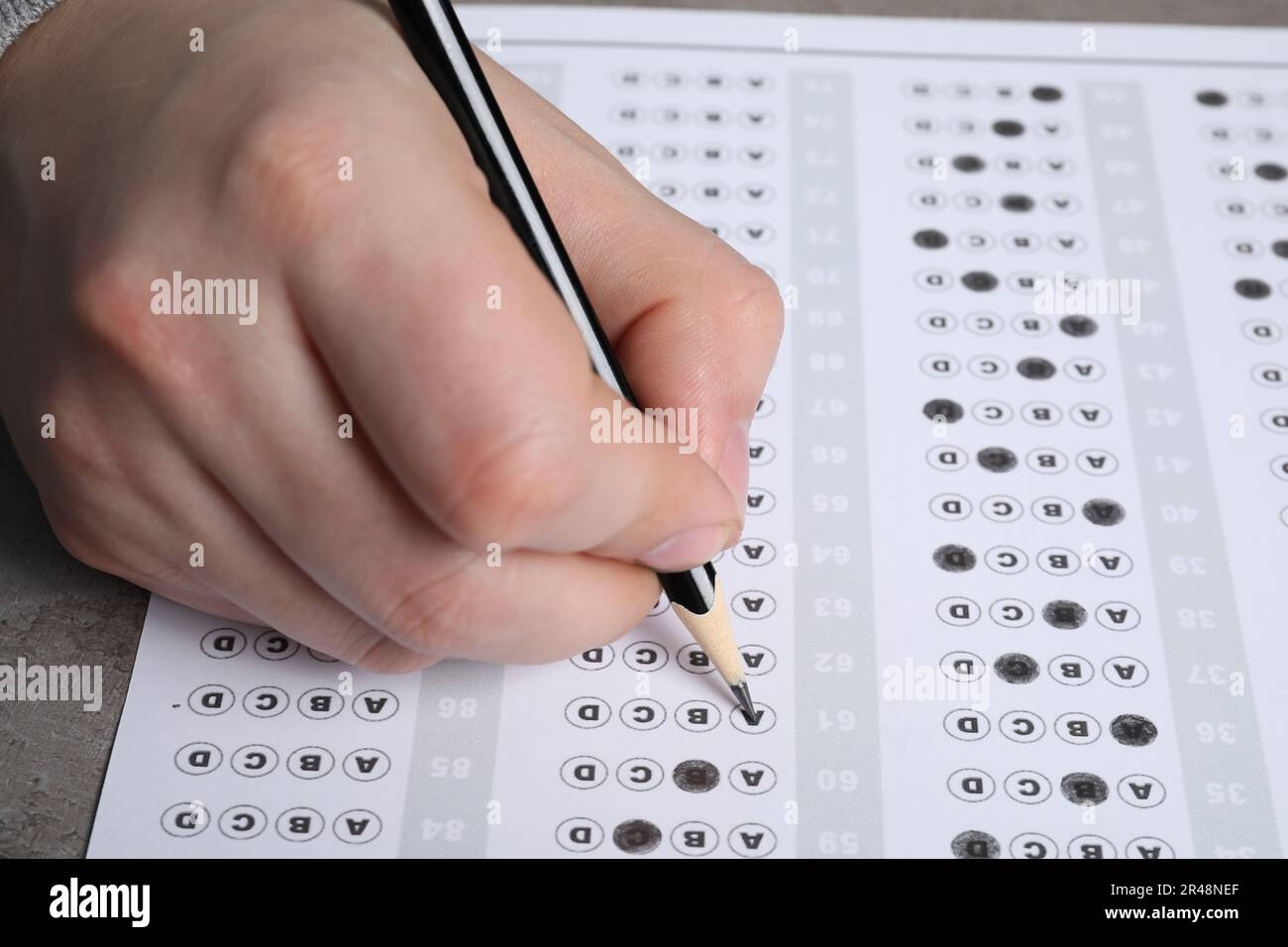 Student filling answer sheet at table, closeup. Passing exam Stock ...