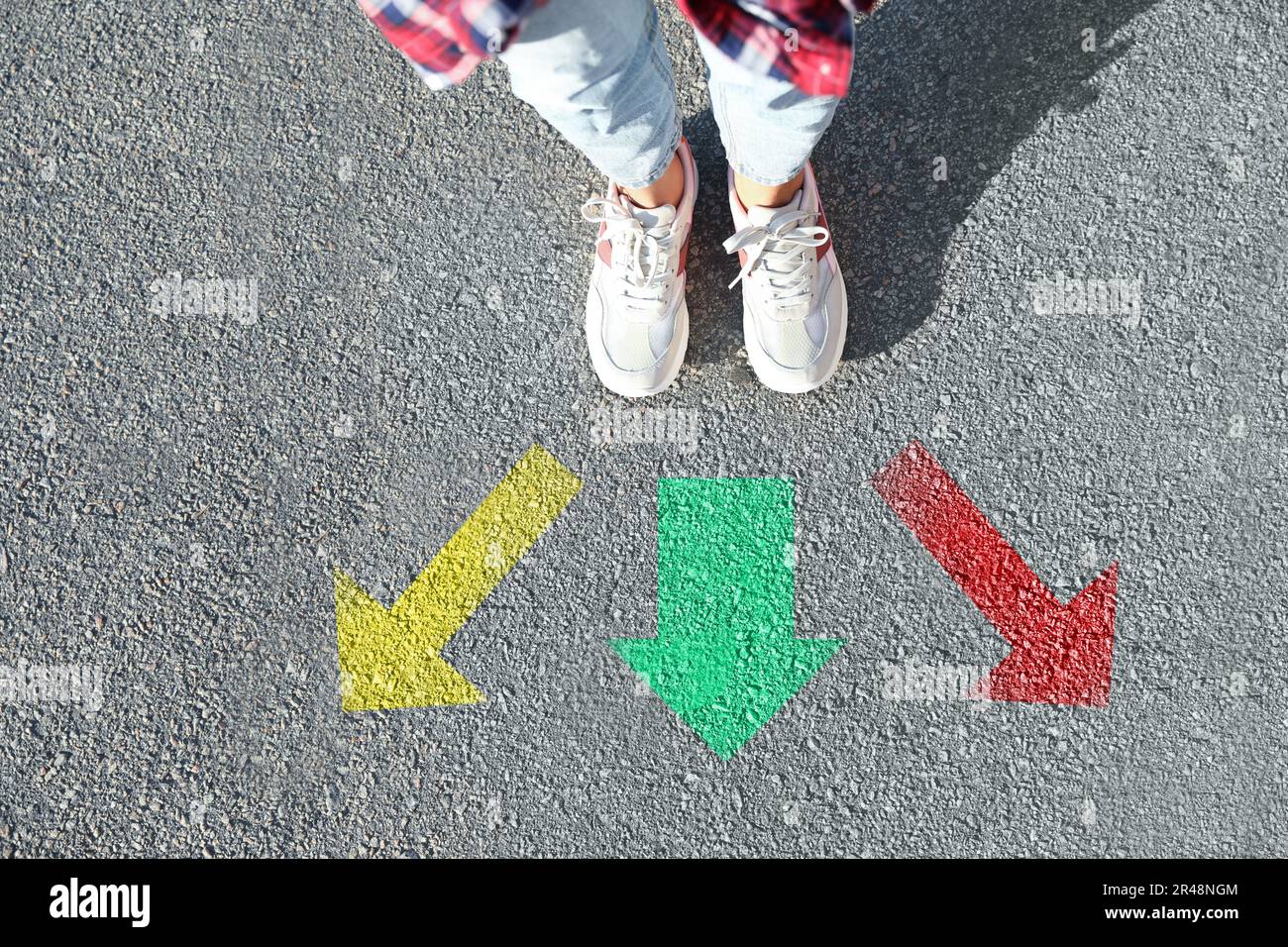 Choice of way. Woman standing in front of drawn marks on road, closeup ...