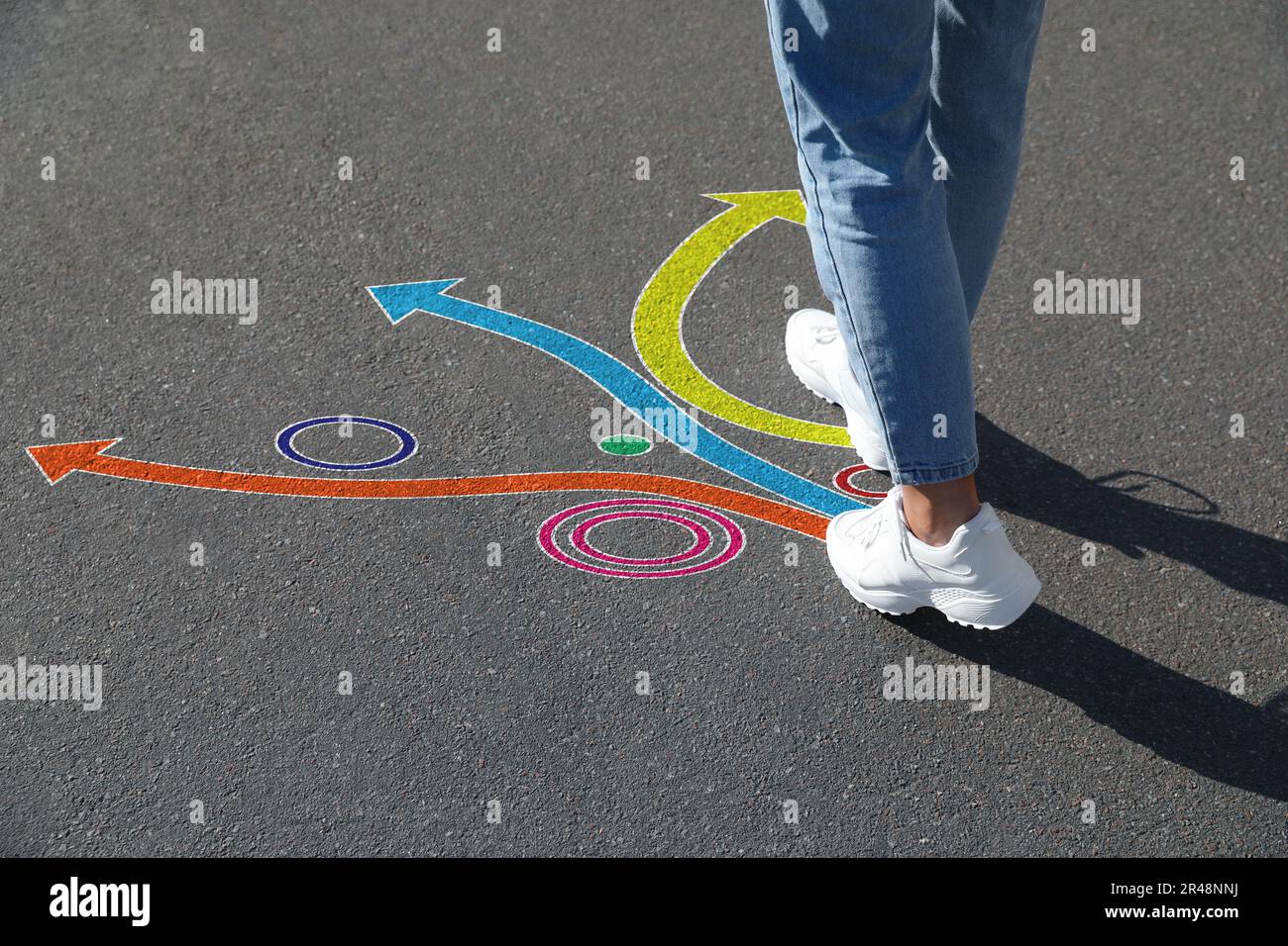 Choice of way. Woman walking towards drawn marks on road, closeup ...