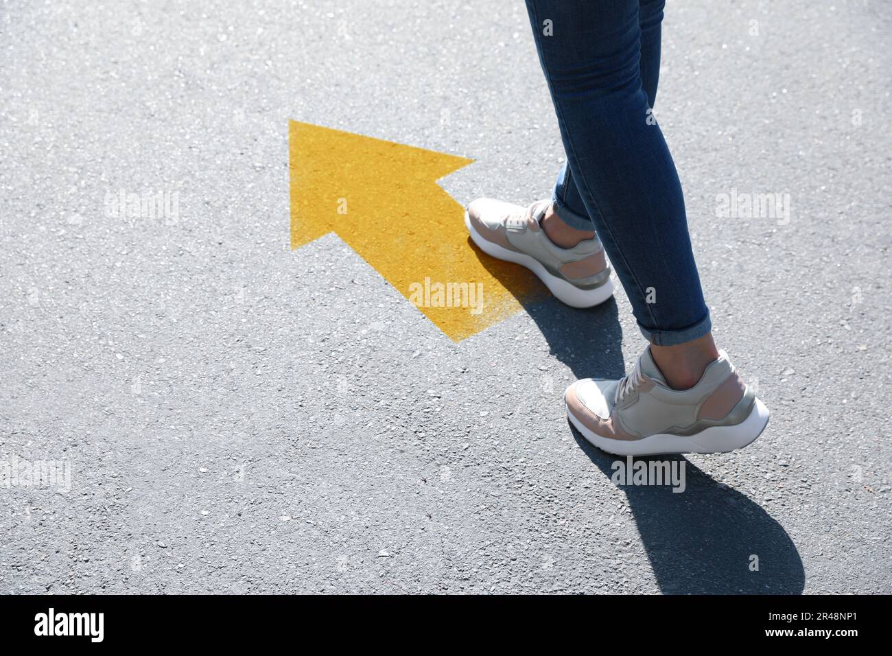 Planning future. Woman walking to drawn mark on road, closeup. Yellow ...
