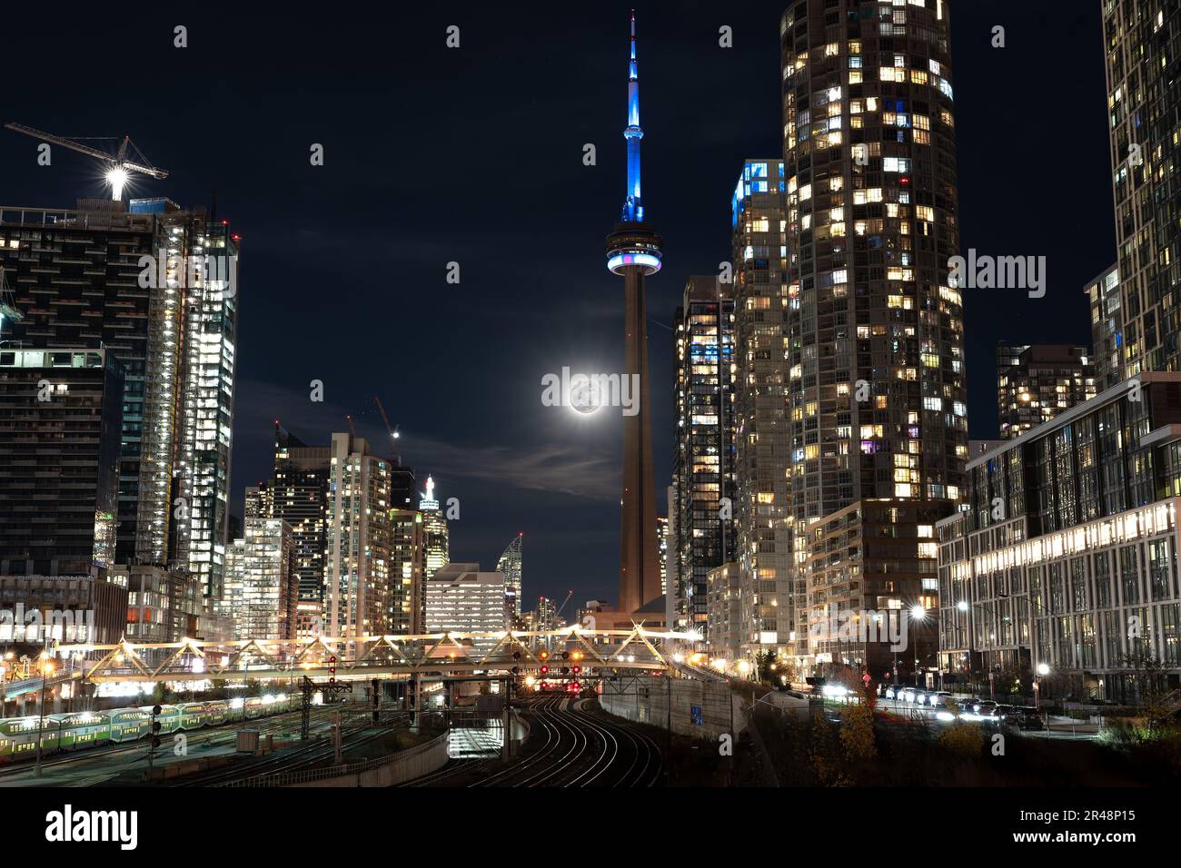 A night view of Toronto city skyline illuminated by a full moon in the ...