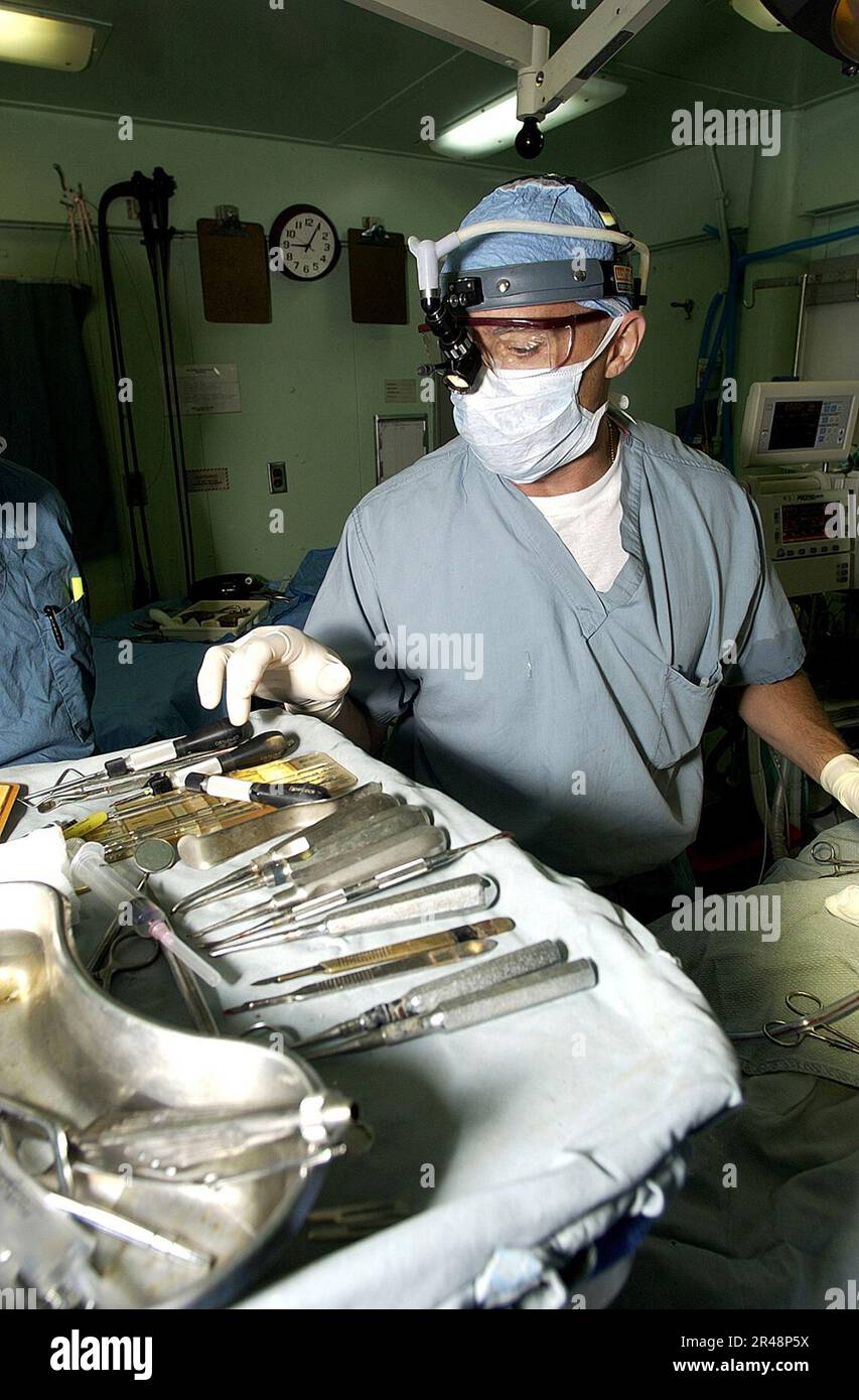 US Navy ship's oral surgeon, looks over his instruments during a ...