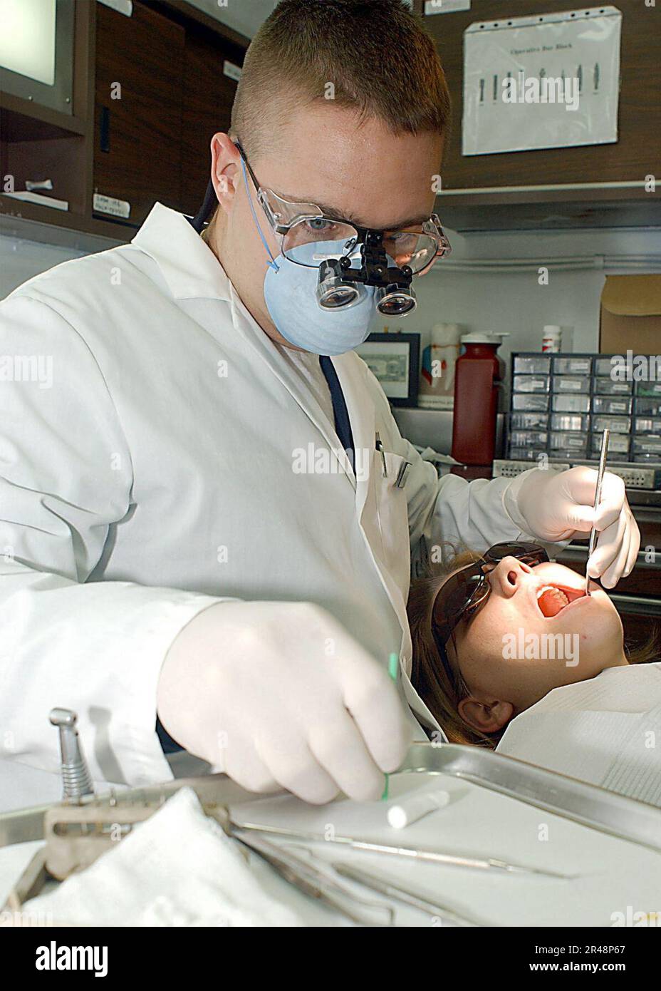 US Navy A Dental Officer works on a Patient in the Ship's Dental ...