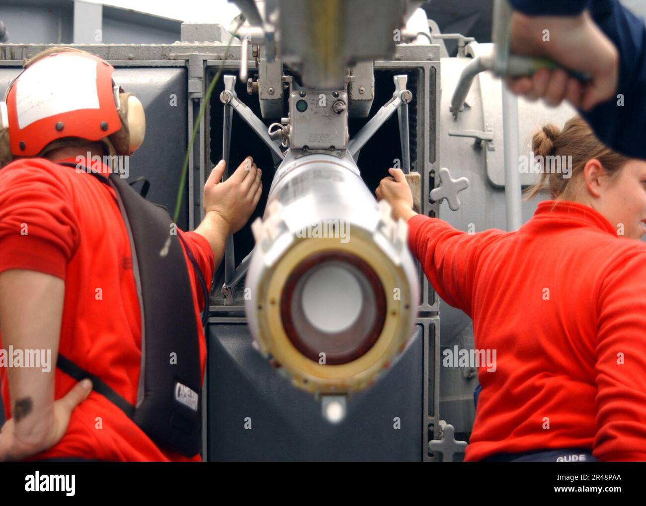 US Navy Sailors load RIM-7 missiles into launcher aboard CVN 72 Stock ...