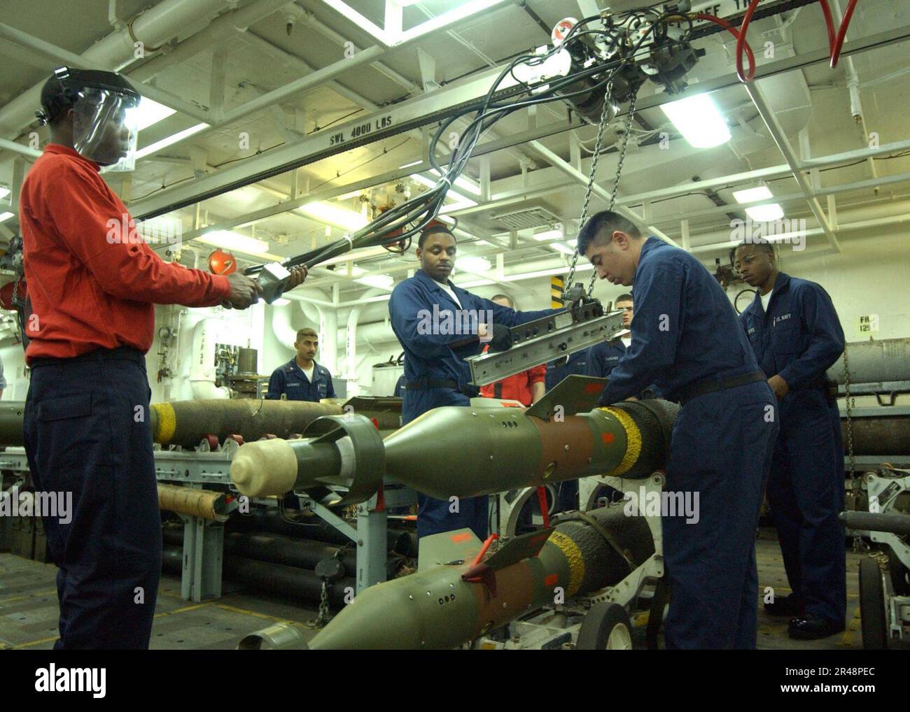 US Navy Sailors aboard CVN 73 dismantal a MK-82 bomb in one of the ship ...