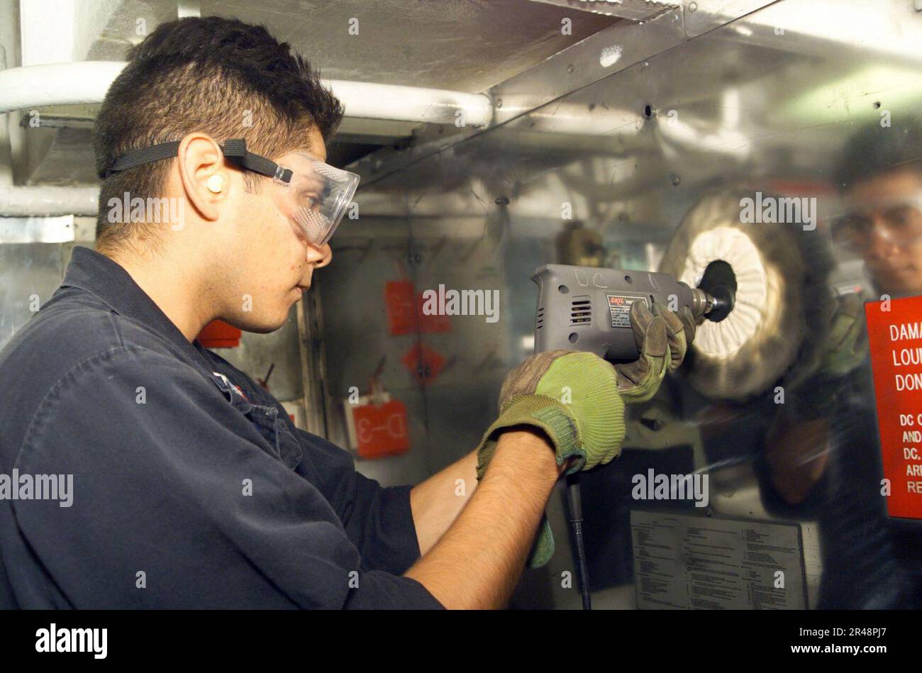 US Navy Damage Controlman buffs a stainless steel bulkhead in Damage ...