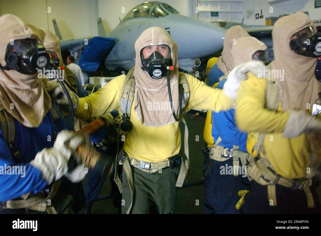 US Navy Sailors assigned to the hangar bay firefighting team simulate ...