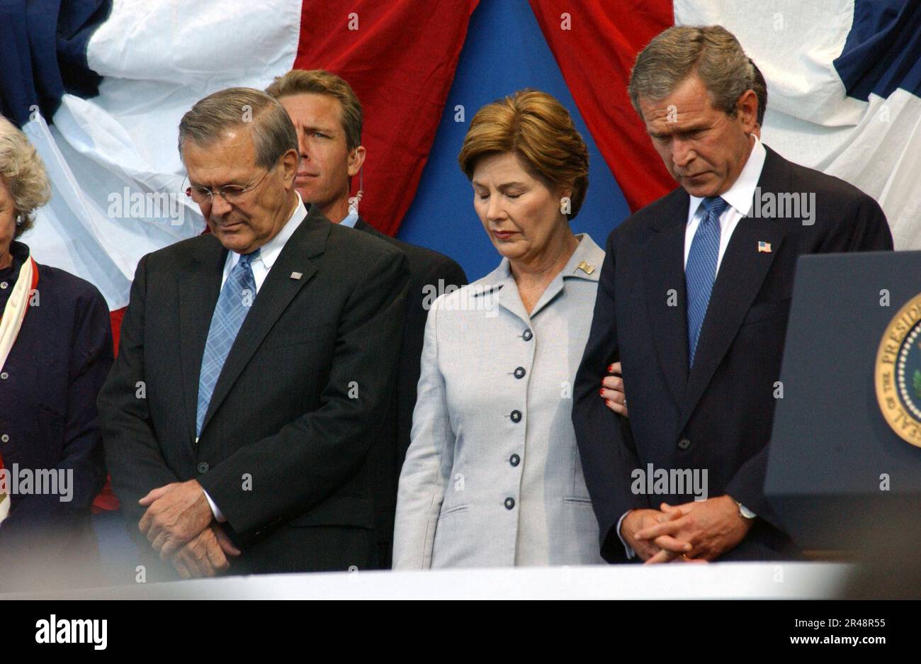 US Navy Official party bow their heads in a moment of silence during ...