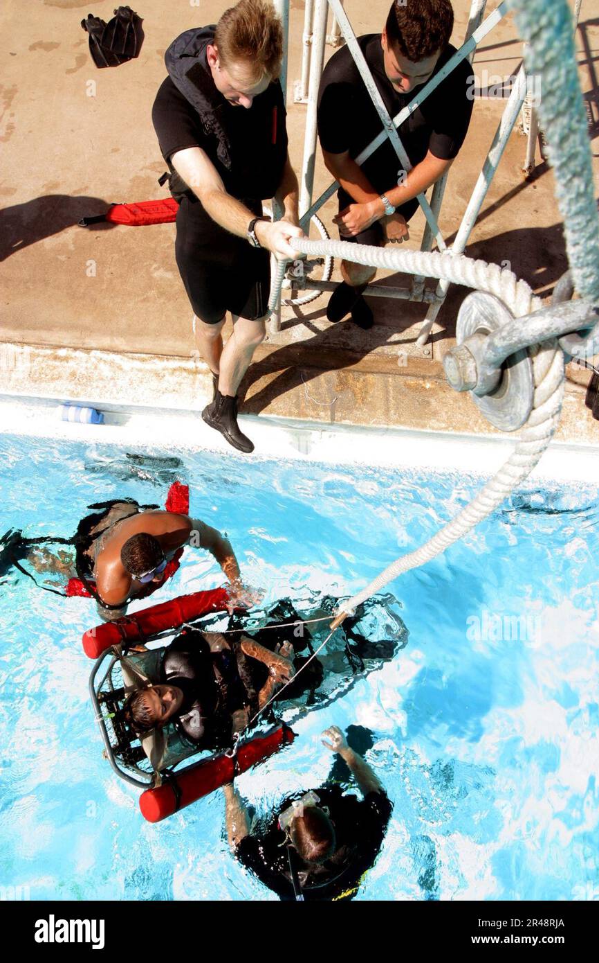 US Navy Search and Rescue (SAR) Instructors and students use a winch to ...