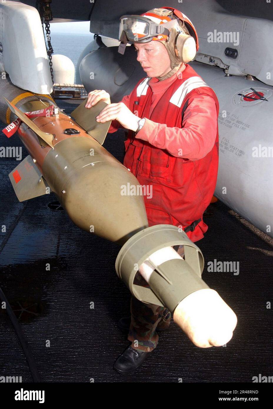 US Navy Aviation Ordnanceman ensures that stabilizers on the guidance ...