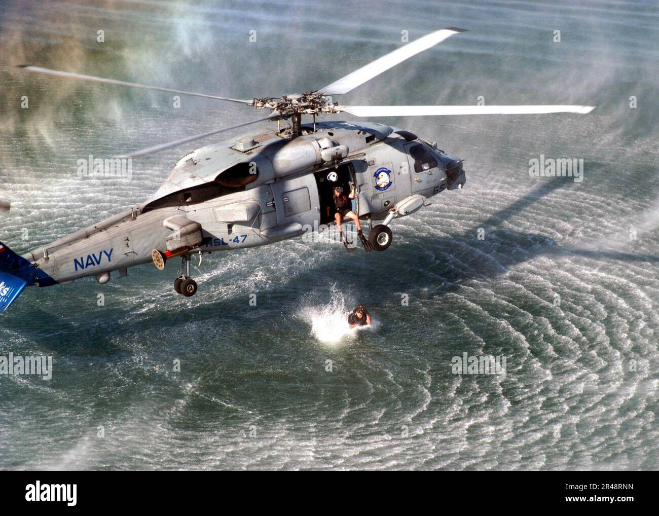 US Navy A Search and Rescue (SAR) swimmer prepares to jump from an SH ...