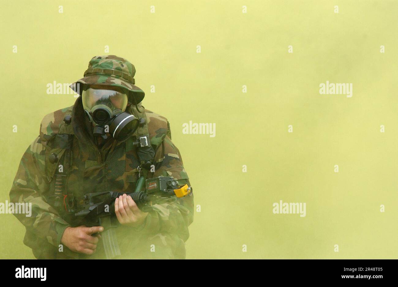 US Navy Photographer's Mate 1st Class practices donning his gas mask ...