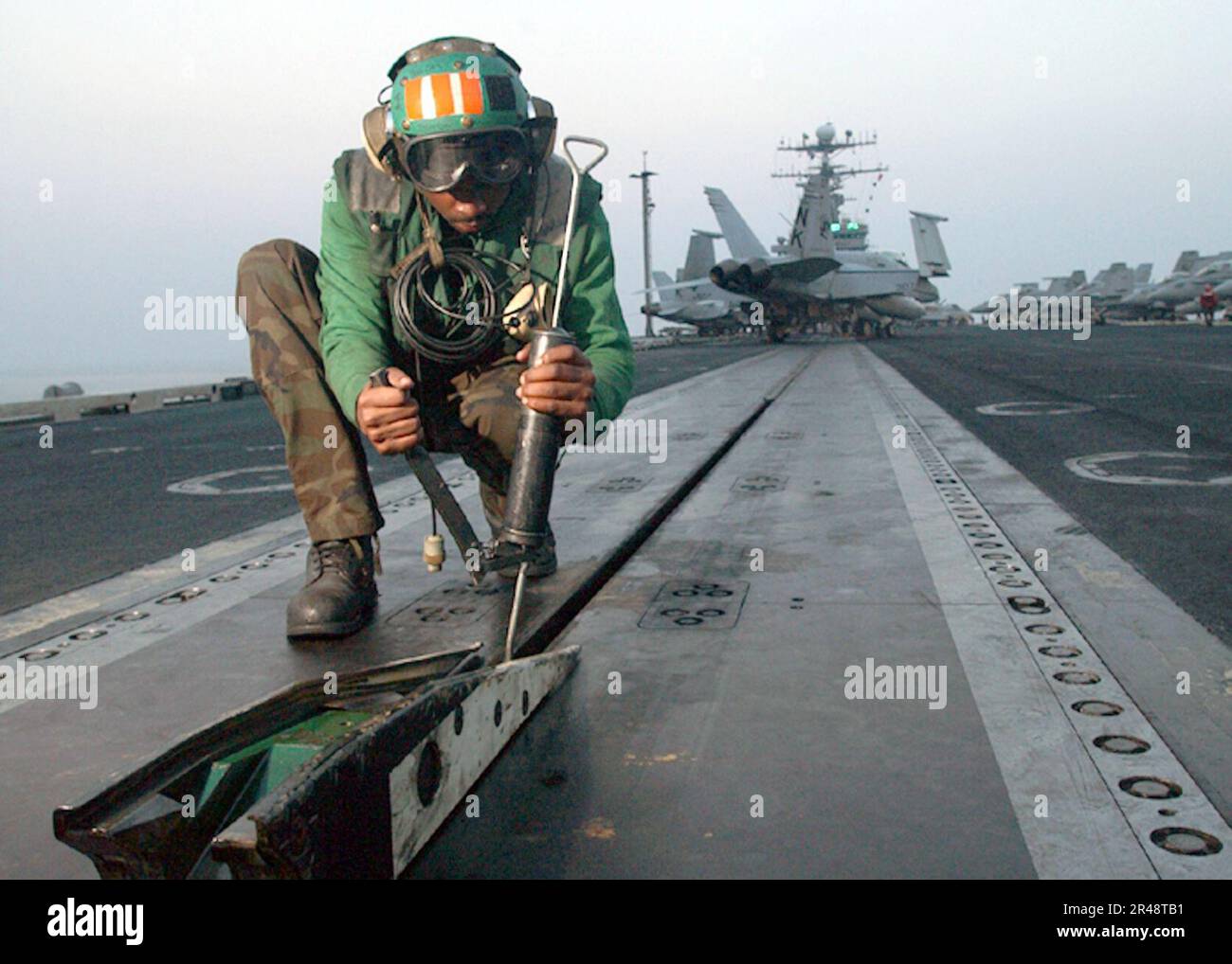 US Navy Greasing one of four steam driven catapults on the ship's ...