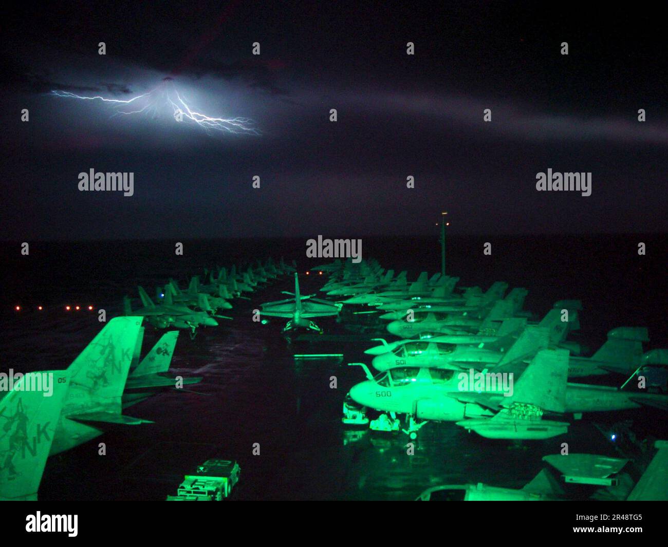 US Navy Lightning fills the horizon, and lights up the flight deck and ...