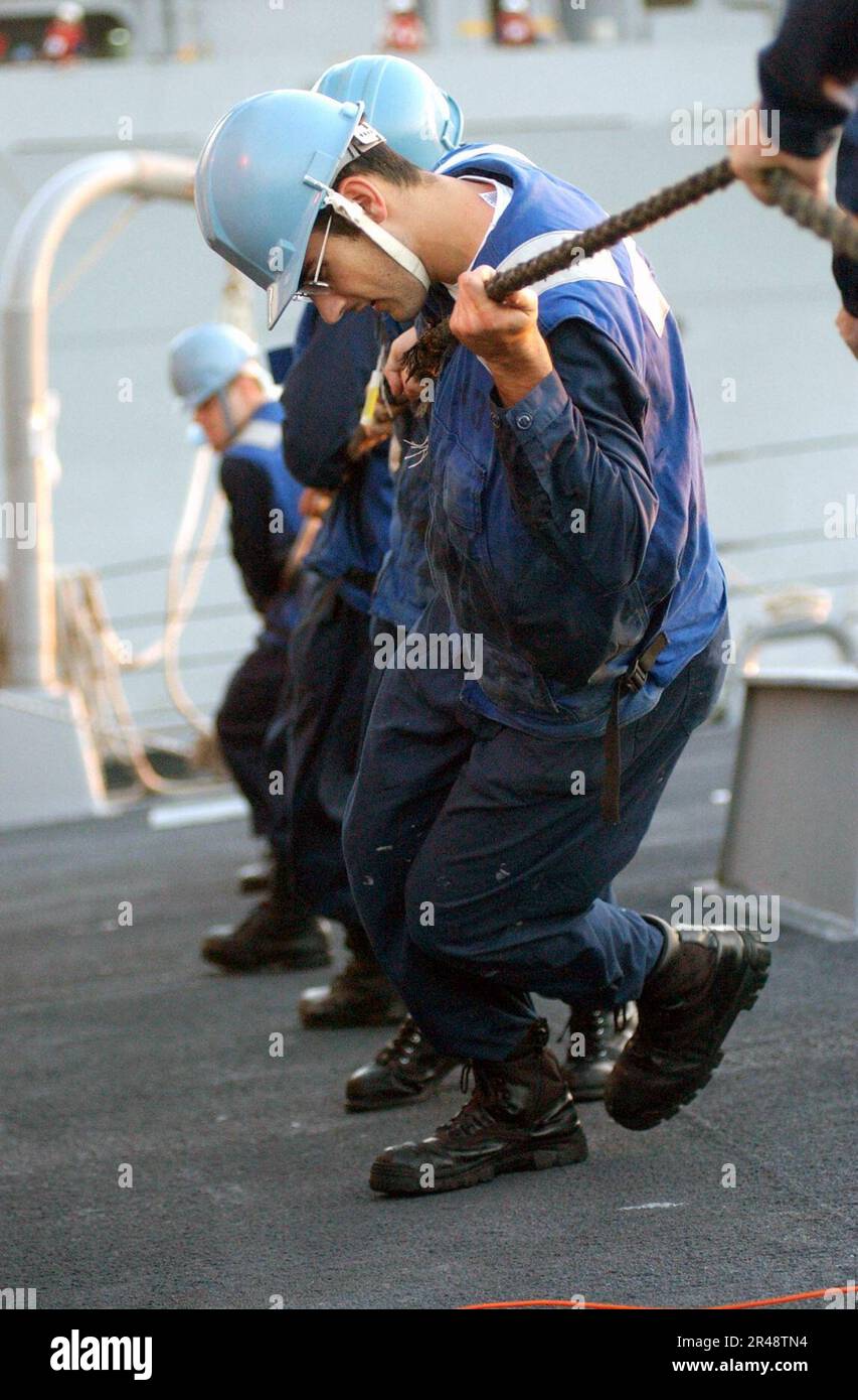 US Navy Sailors heave on the messenger line to prepare for an early ...