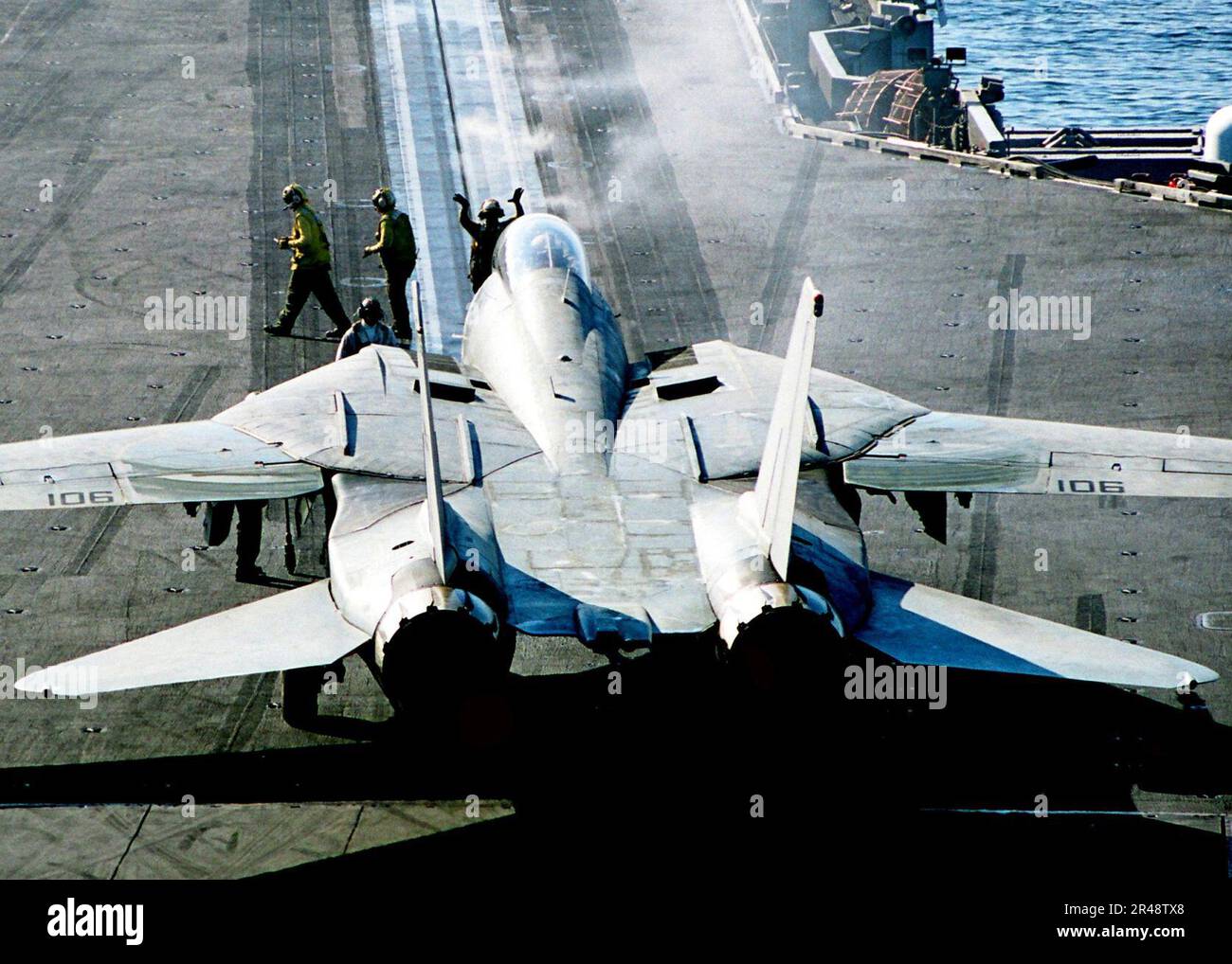 US Navy A Flight Deck Director guides an F-14D Tomcat fighter onto ...