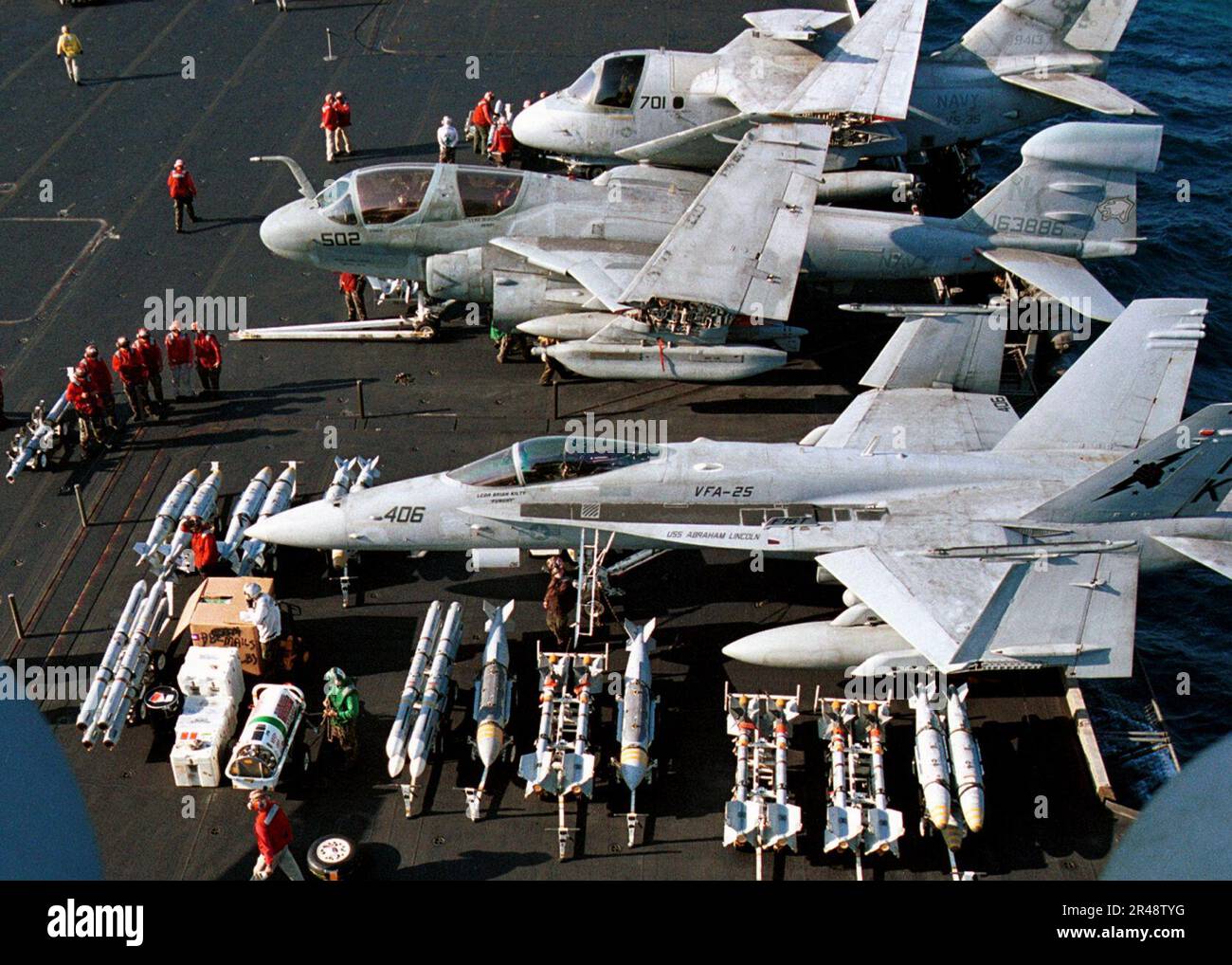 US Navy Aviation Ordnancemen prepare to load aircraft with various ...