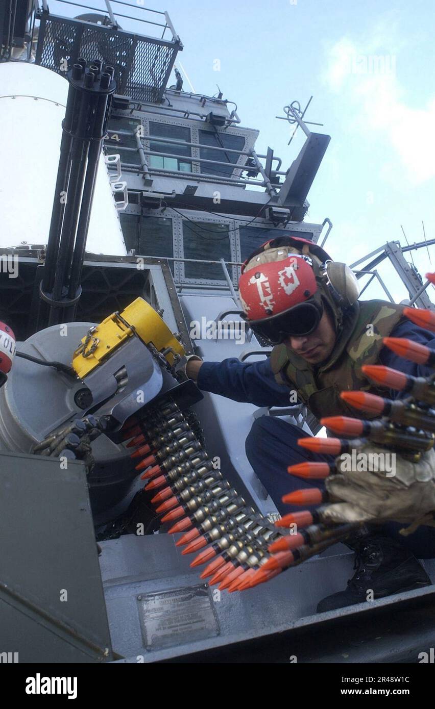US Navy A sailor guides 20mm rounds while loading the Close-In Weapons ...