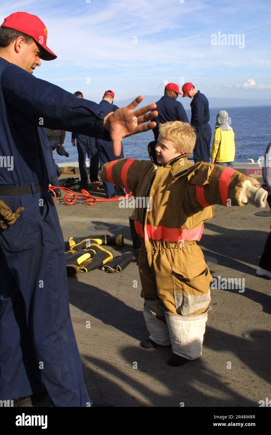 US Navy A youngster tries on Fire Fighting Ensemble Stock Photo - Alamy