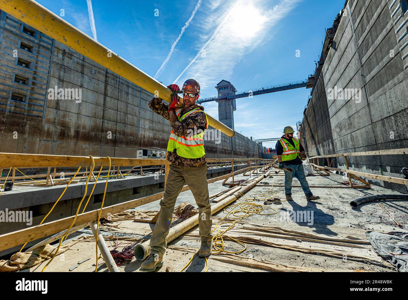 Construction laborers perform work on the chamber floor concrete infill ...
