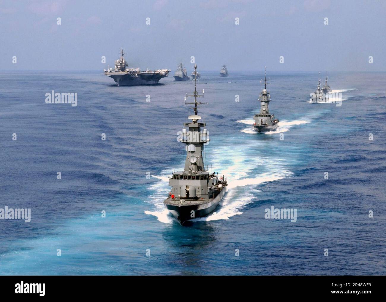 US Navy Constellation steams through the ocean with ships in its Battle ...