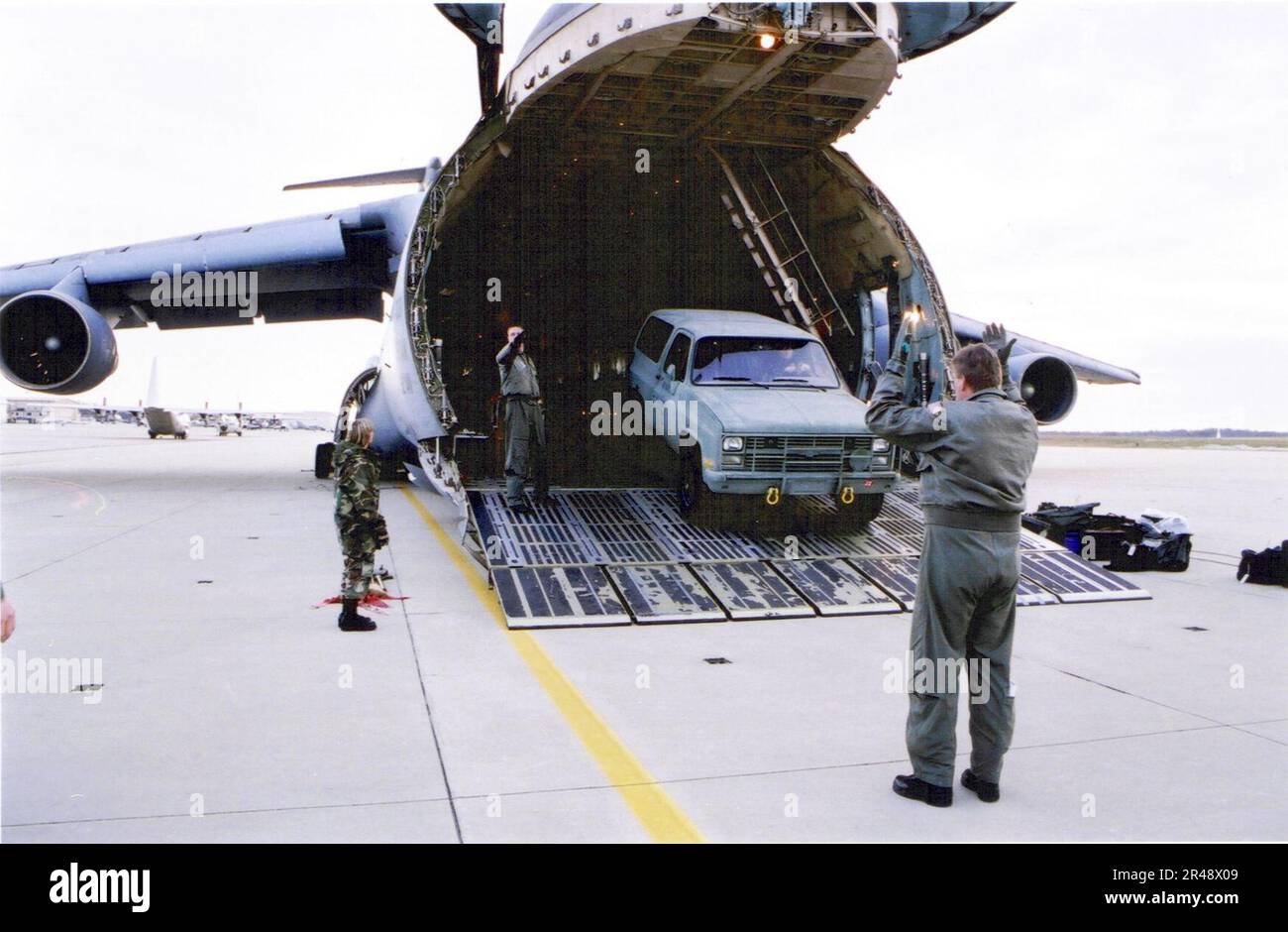 US Navy Crewmen direct a Seabee attached to Naval Mobile Construction ...