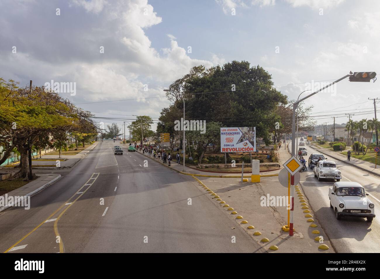 Cars parked alongside a highway in a suburban setting, with street ...