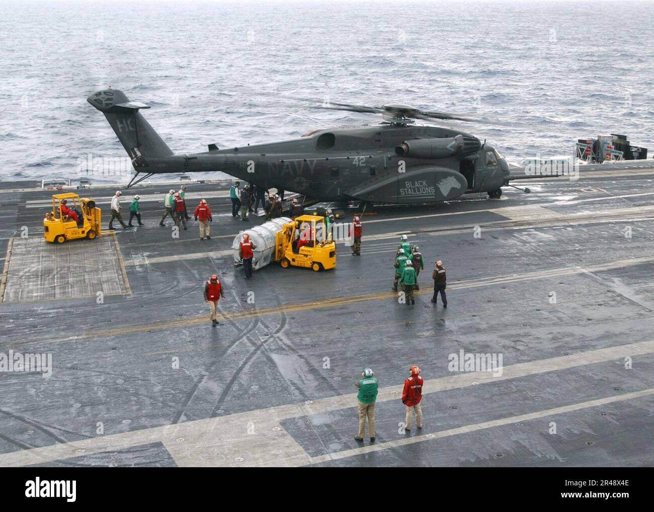 US Navy Sailors aboard the Harry S. Truman offload a jet engine from a ...