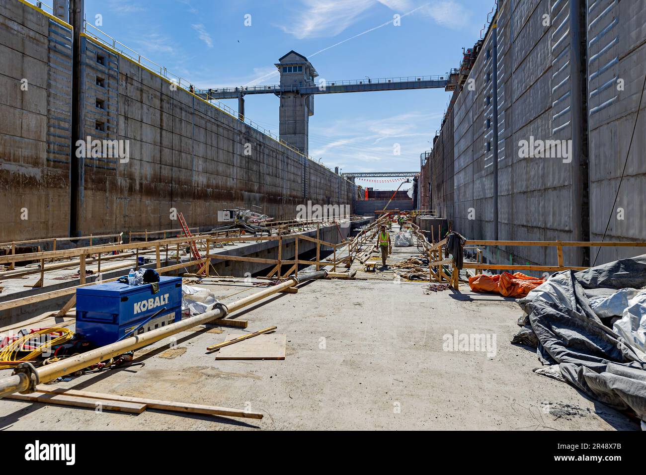 Construction laborers perform work on the chamber floor concrete infill ...
