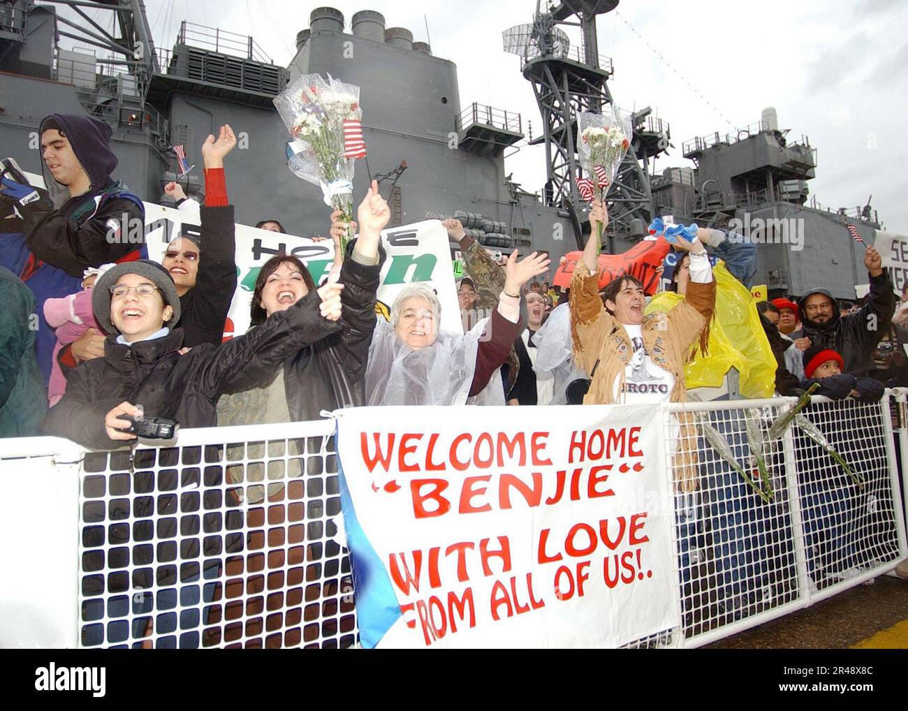US Navy Family members and friends cheer on as they watch the arrival ...