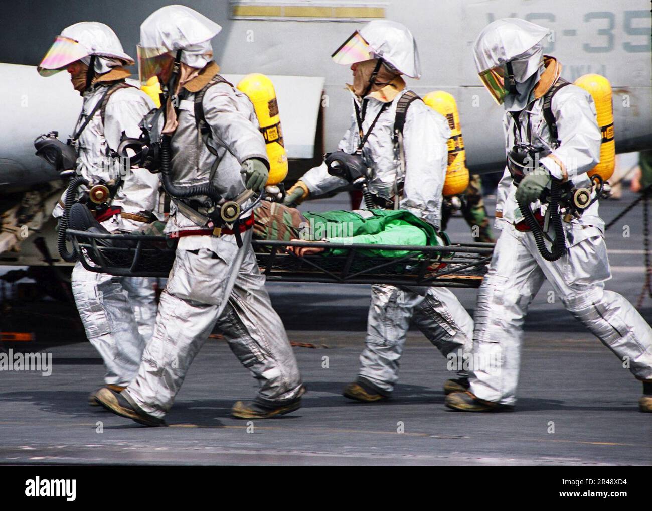 US Navy Crash and Salvage Rescue Team carries an injured sailor on a ...