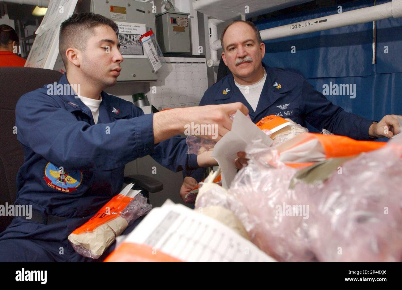US Navy inspecting aircraft components while entering data into the ...