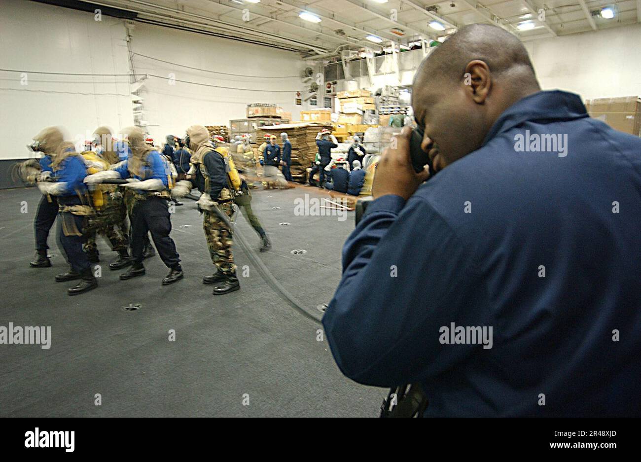 US Navy Photographer's Mate photographs sailors while they practice ...