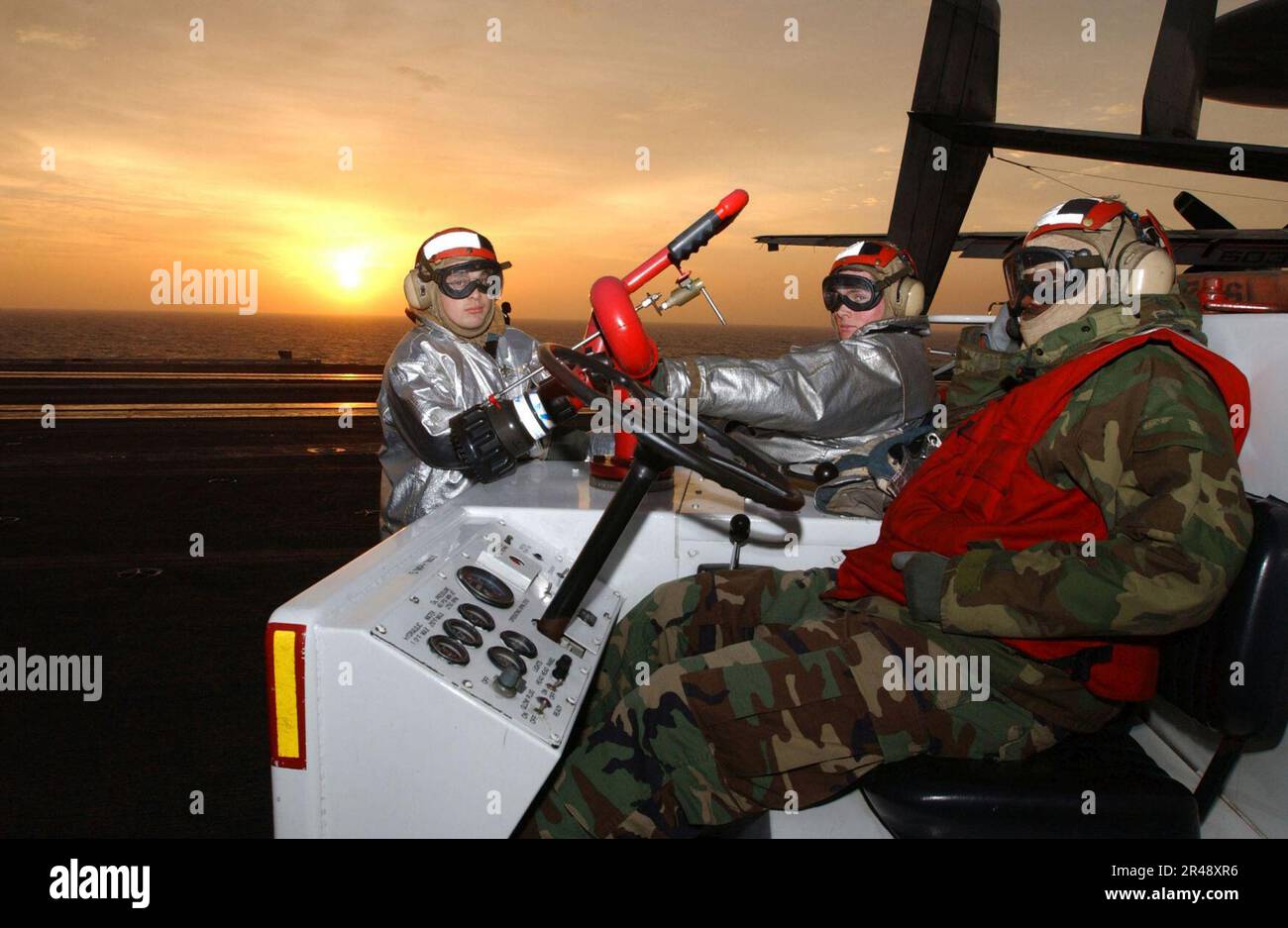 US Navy fire watch on the ship's flight deck with the P-25 fire truck ...