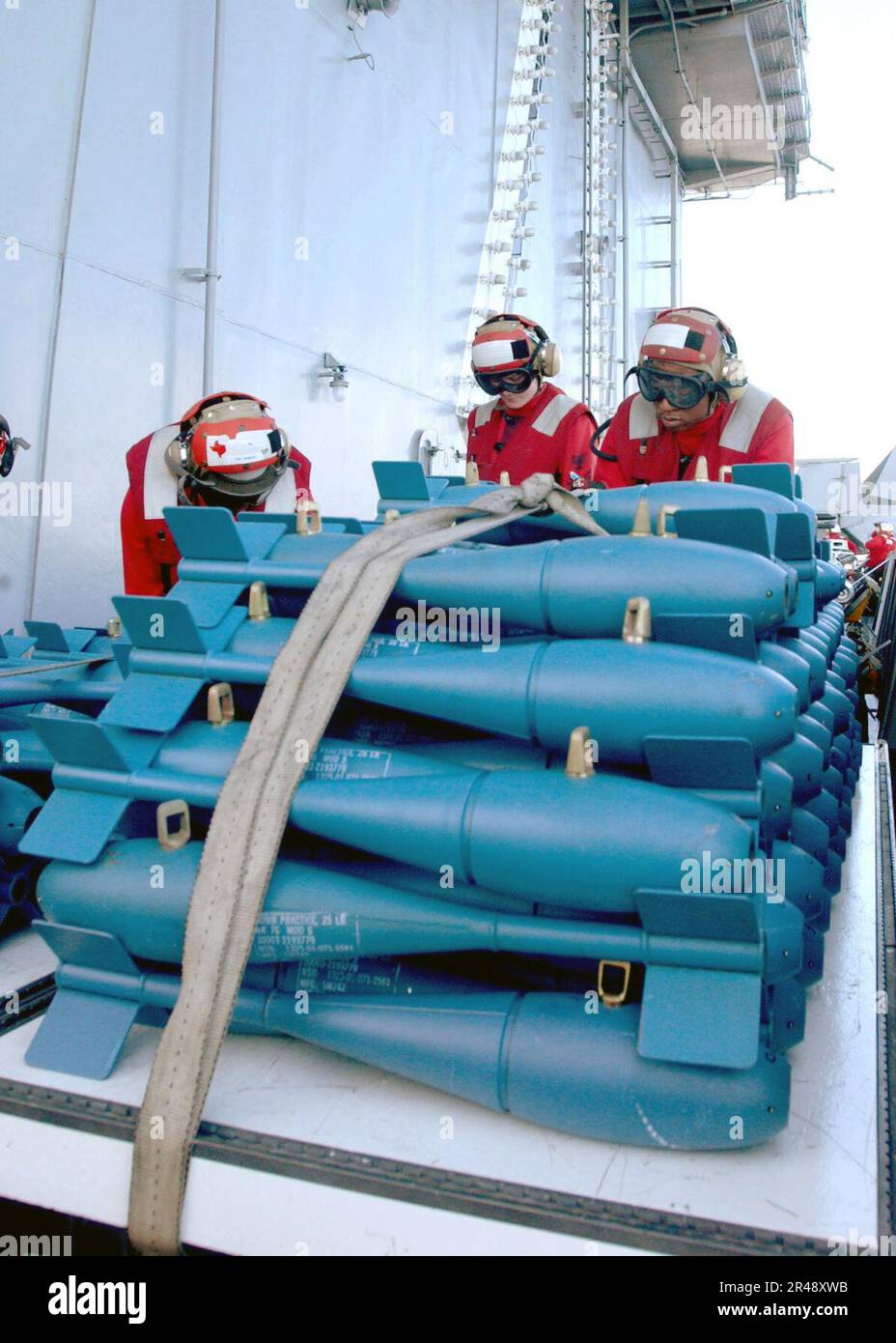 US Navy Aviation Ordnanceman prepare MK-76 practice bombs to be issued to squadrons aboard the ...