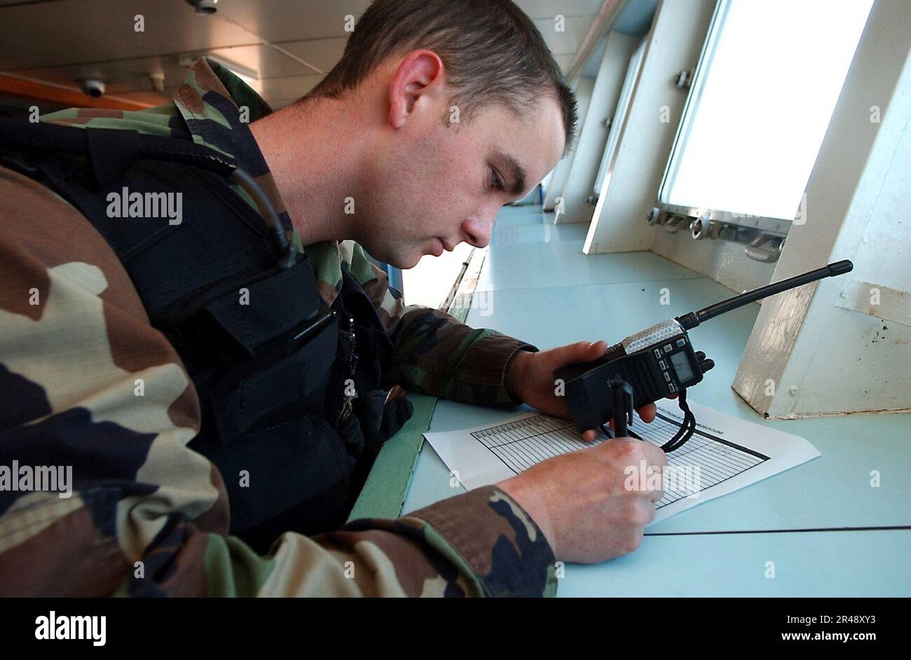 US Navy Sailor writes the model name and serial number of the cargo ...