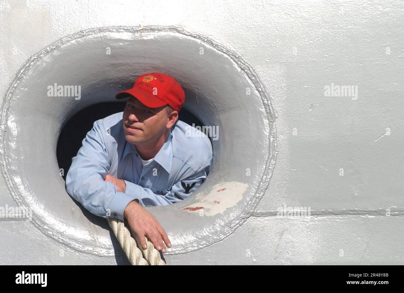 US Navy A Sailor aboard USS Boxer glances through a port hole Stock ...