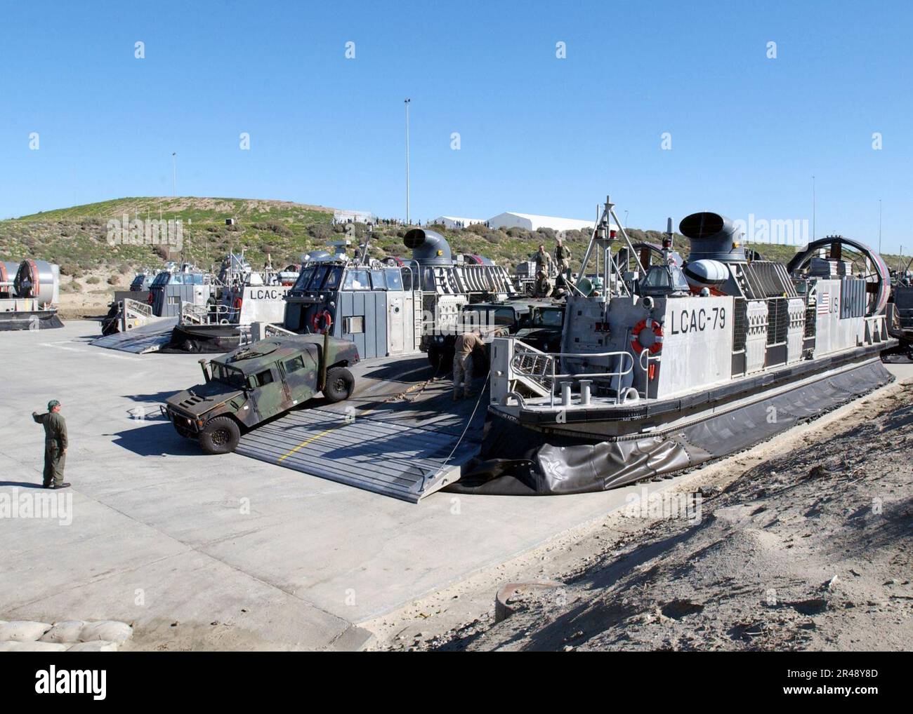 US Navy A sailor from Assault Craft Unit Five (ACU-5) guides elements ...
