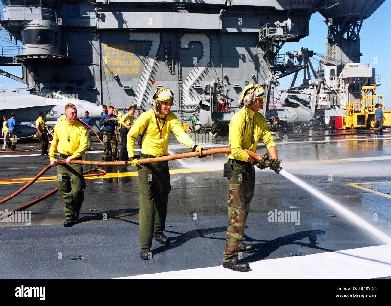 US Navy Sailors spray down sections of USS Abraham Lincoln's non-skid ...