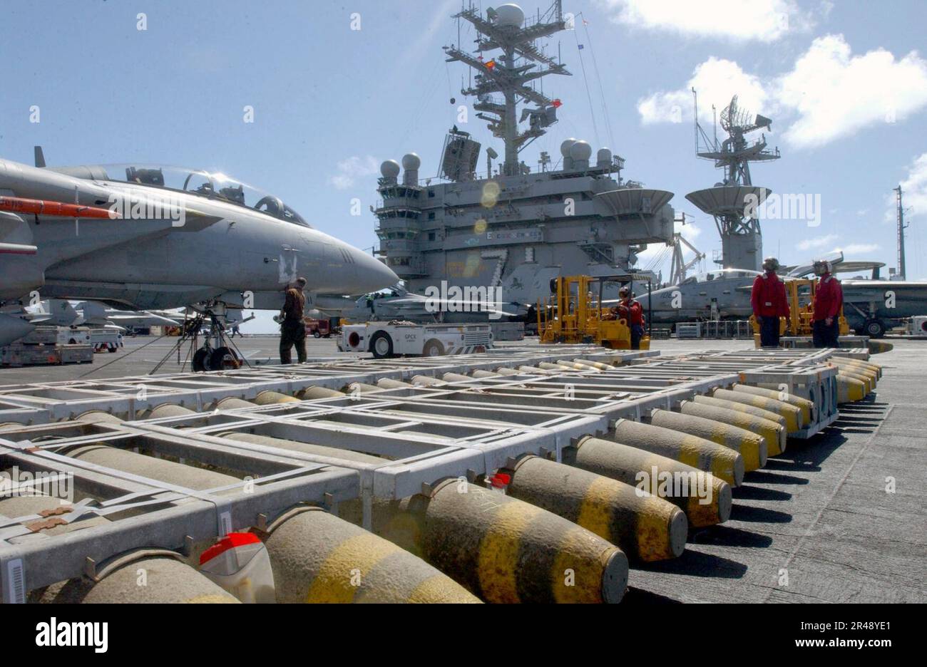 US Navy Aviation Ordnancemen transport bombs from the ship's flight ...