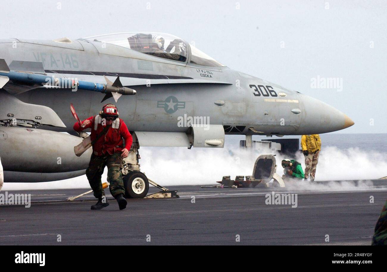 US Navy An aviation ordnanceman clears the catapult area after removing ...