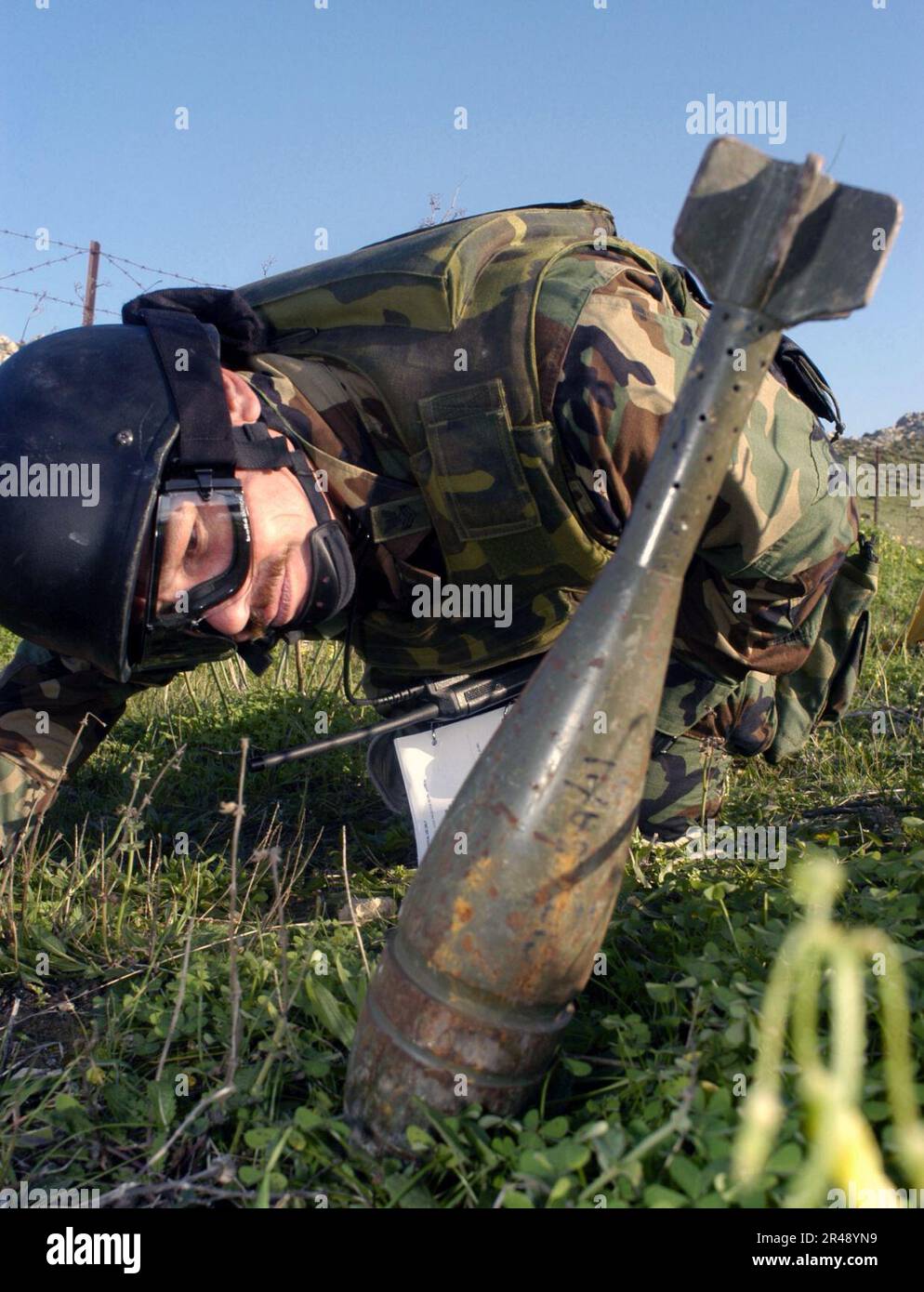 US Navy Quartermaster 1st Class examines an inert mortar round in an ...