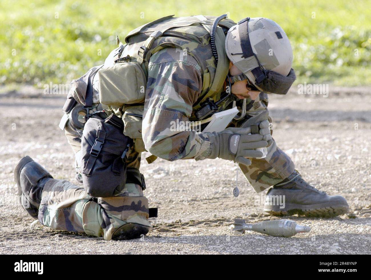 US Navy Engineman 1st Class photographs an inert mortar round during a ...