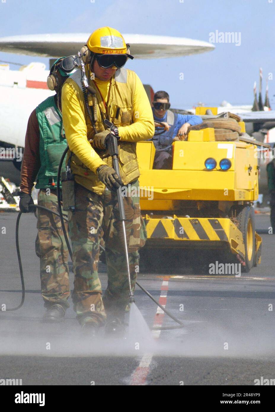 US Navy Two flight deck personnel take the time to clean the foul line ...