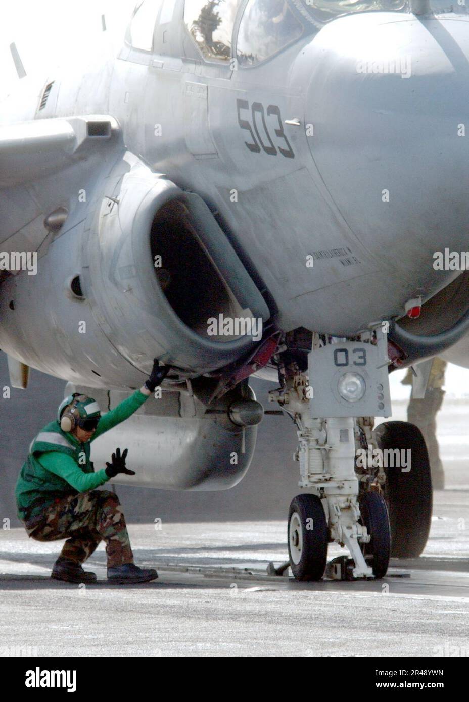 US Navy flight deck crew member assigned to V-2 air department, signals ...