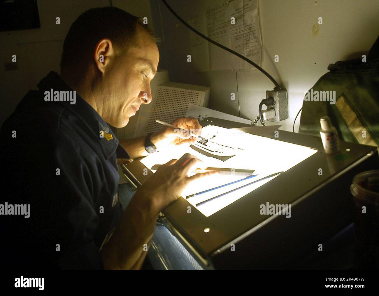 US Navy Illustrator Draftsman designs a training slide with the ...
