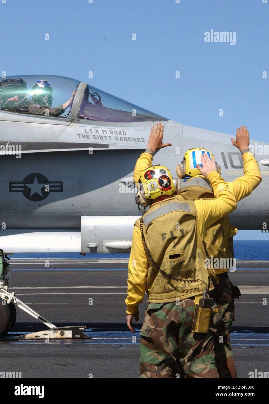 US Navy A flight deck aircraft director stands behind a new director in ...