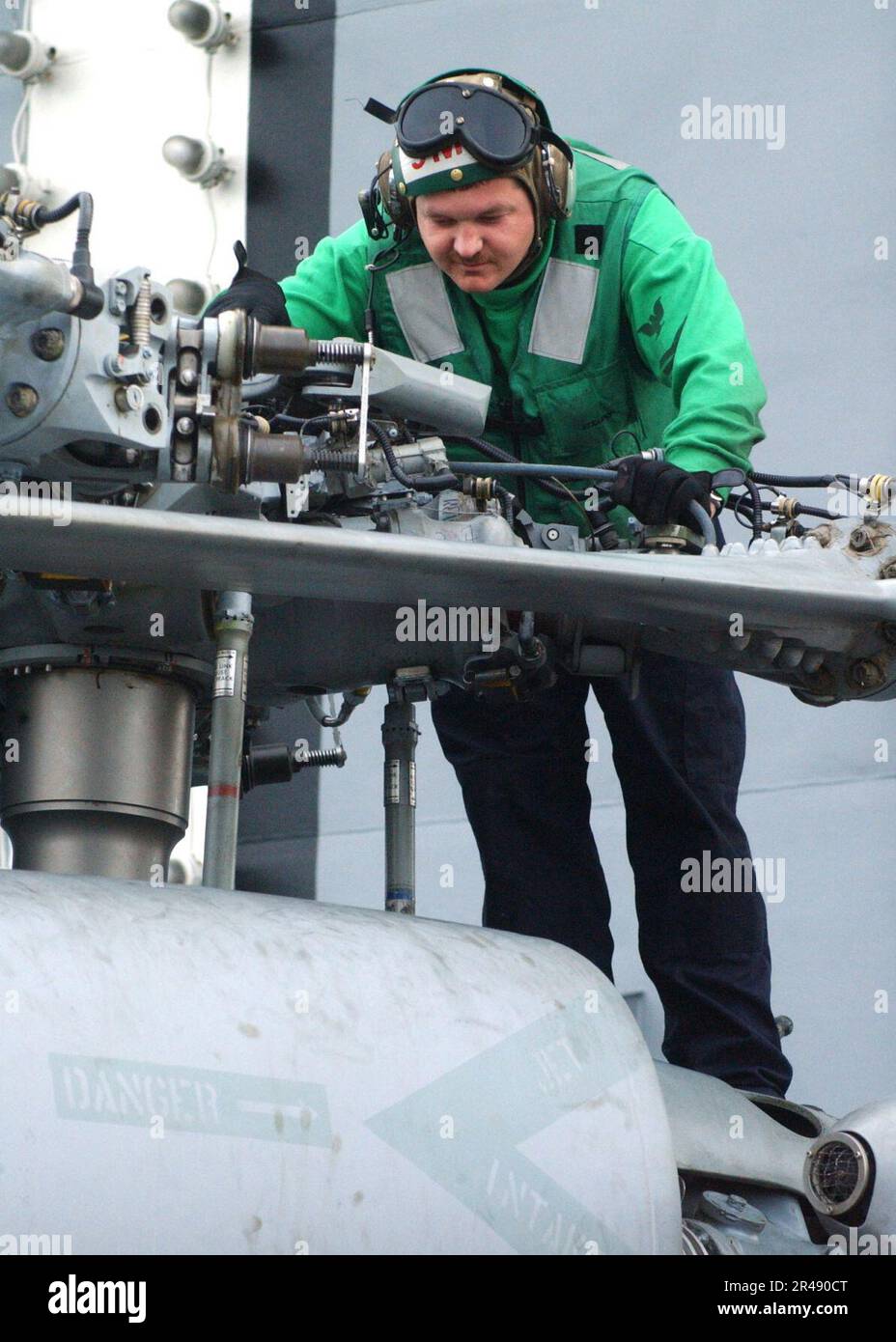 US Navy Aviation Structural Mechanic 1st Class works on the rotor of an ...